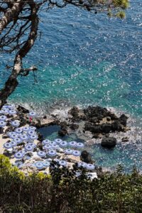 Facing the Faraglioni of Capri, La Fontelina restaurant and beach ...